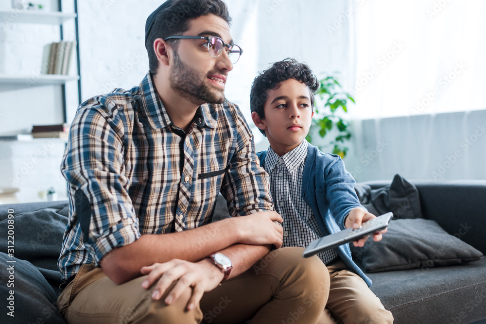 smiling jewish father and son with remote controller watching tv Stock ...