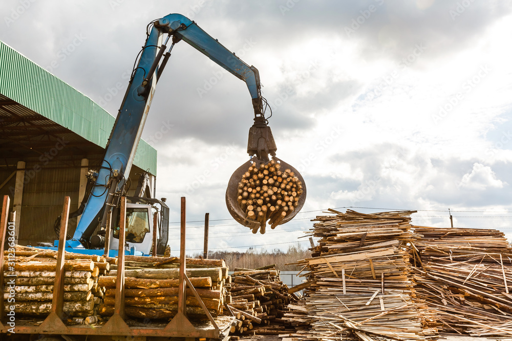 Foto Log loader at lumber mill, sawmill. Front loader lifting stack of ...