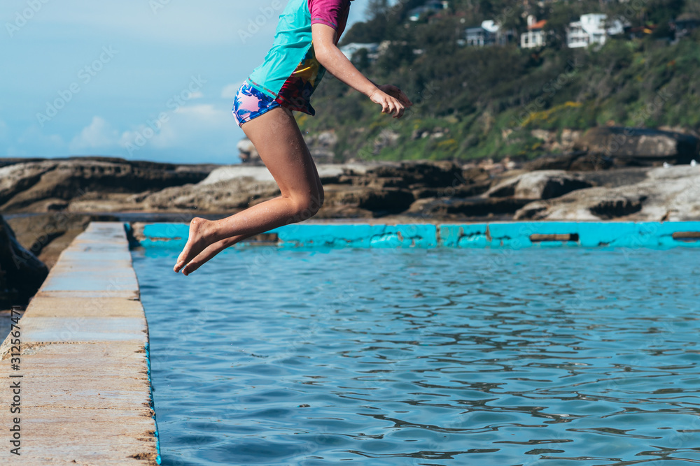 little girl jumping into an ocean pool Stock Photo | Adobe Stock