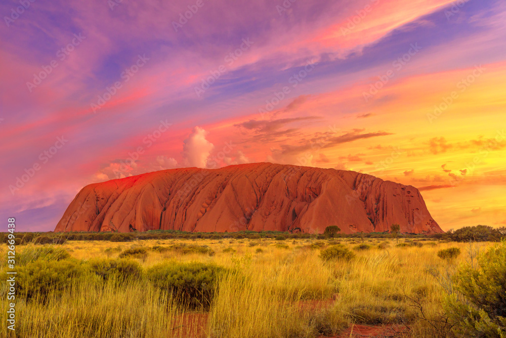 Amazing dramatic colorful sunset sky over Ayers Rock in Uluru-Kata ...