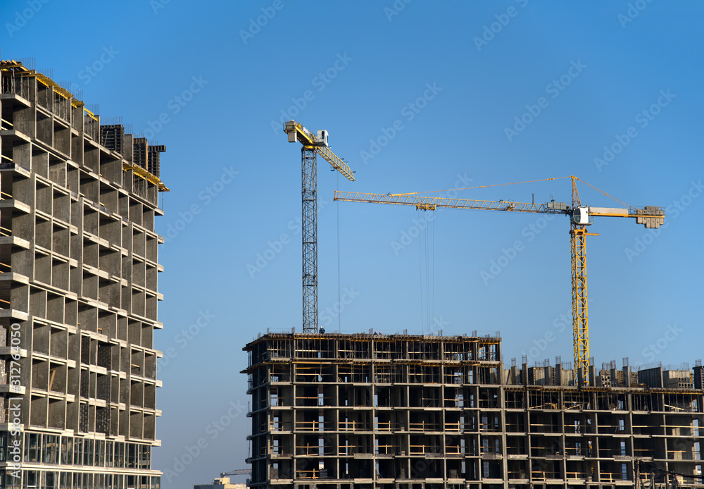 Hydraulic luffing jib tower cranes and workers being poured concrete ...
