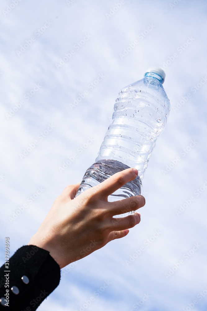 plastic bottles in blue and transparent colors being recycled for an ...