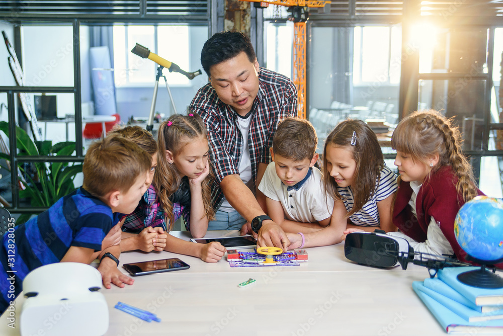 Foto Teacher shows a working model of a wiring diagram to a group of ...