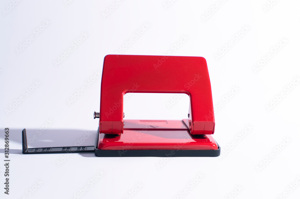 Red hole punch on a white background. Hole puncher with extended paper ...