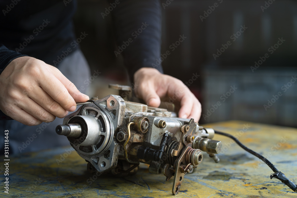Mechanic man trying to remove o-ring seal of diesel injection pump ...