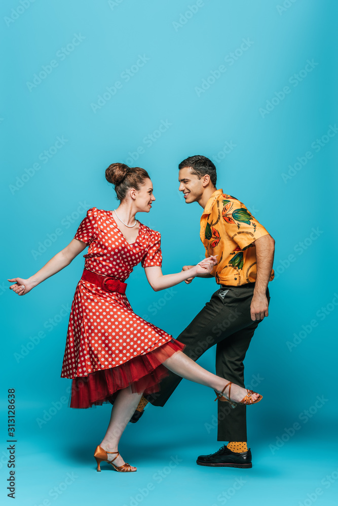 smiling dancers looking at each other while dancing boogie-woogie on ...
