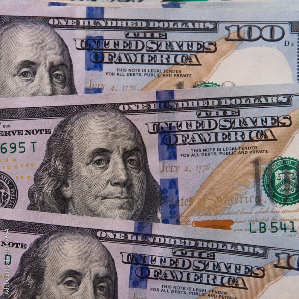one hundred dollar money dollars with the image of Franklin spectacled ...