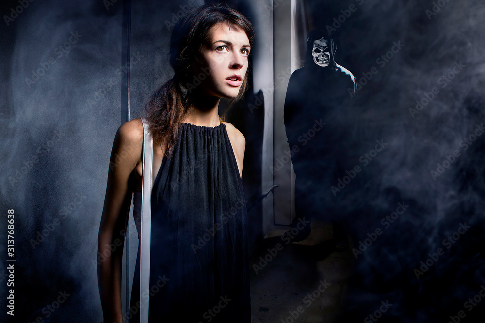 Woman in a dark alley with fog or mist imagining or seeing a demon or ...