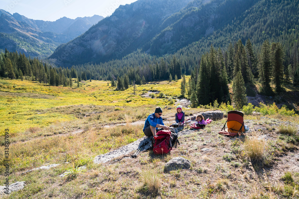 Familiy of four, with two young children, relaxing around camp and ...