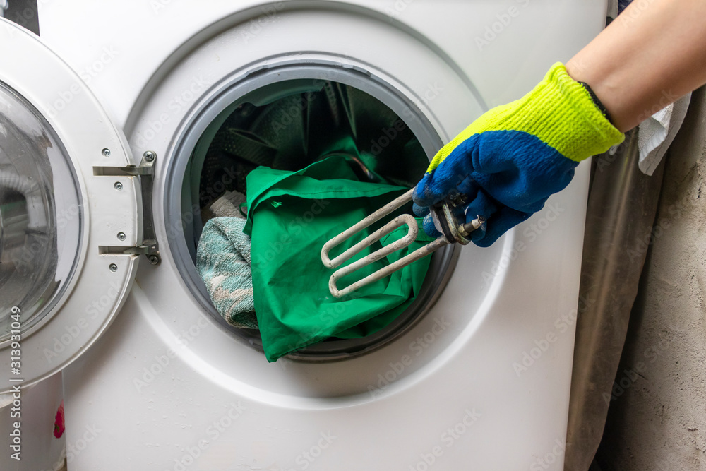 Photo Stock washing machine breakdown. The master retrieves the floor ...