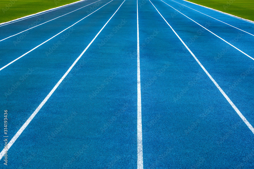 Blue running treadmill track with lane numbers in stadium outdoors ...