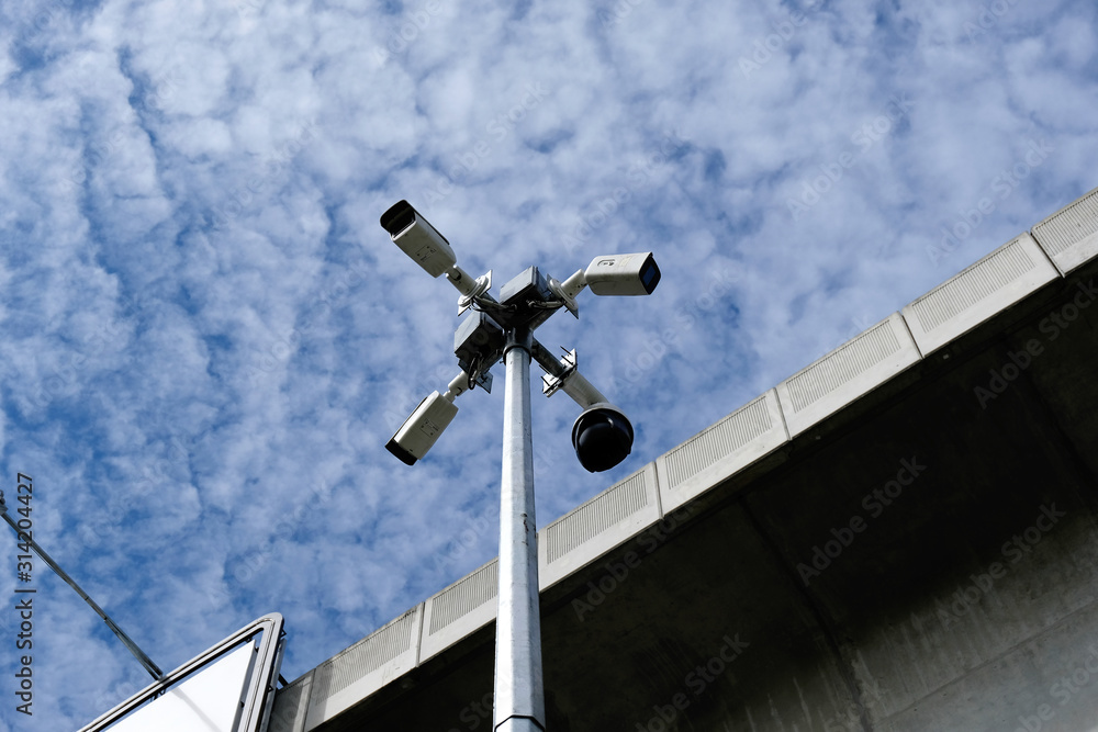 Surveillance camera at a street intersection monitoring road traffic in ...