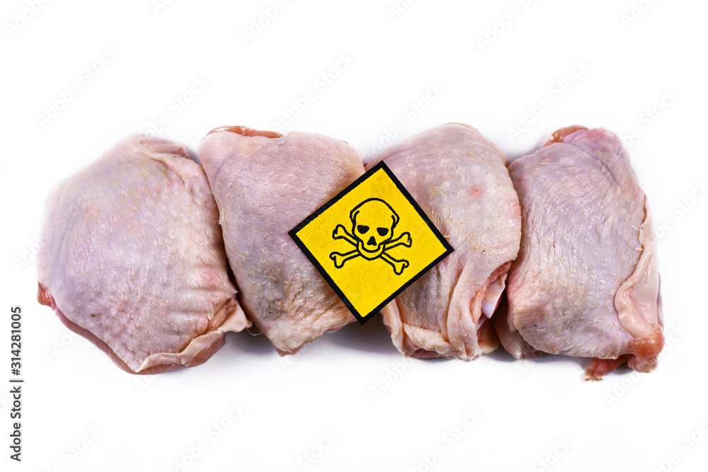 Raw chicken meat with yellow poisonous skull warning sign, concept for ...