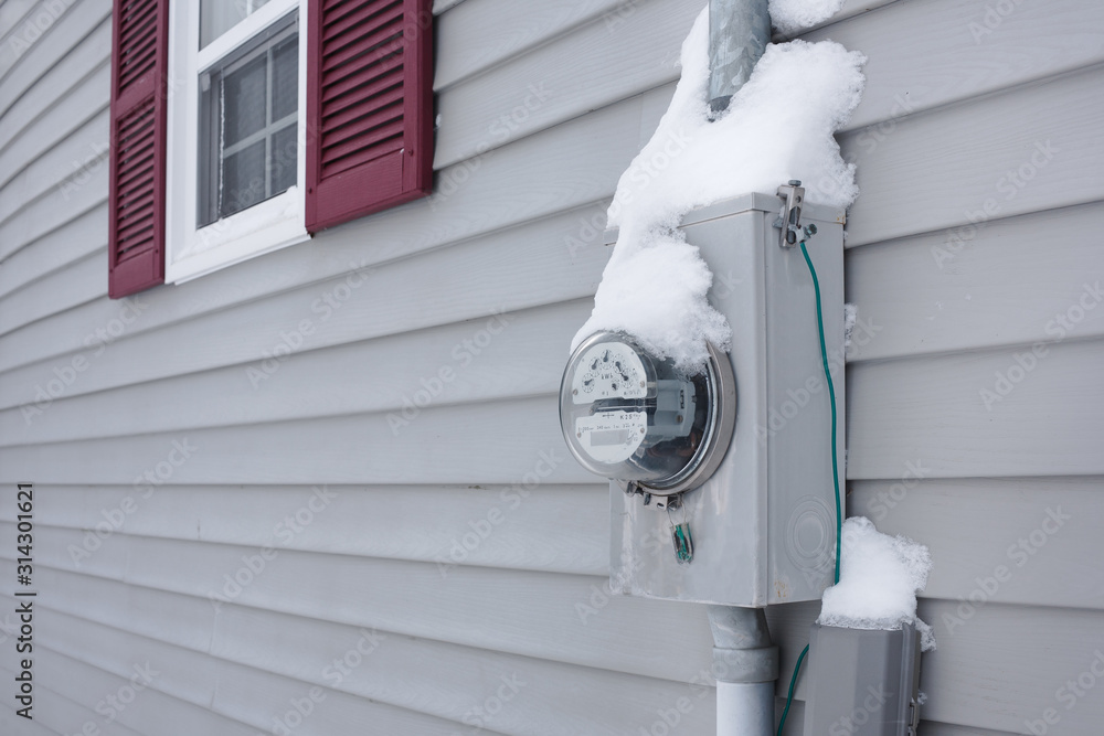 Frozen electrical utility meter on house exterior siding. Stock Photo ...