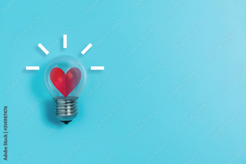 Red heart in light bulb on blue background with copy space. Stock Photo ...