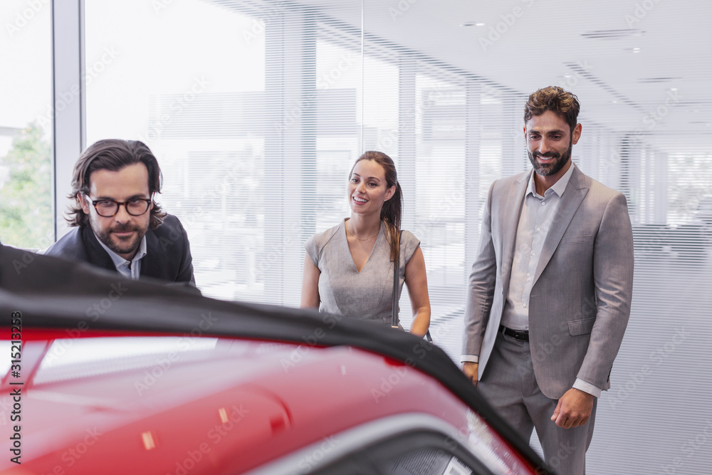 Foto de Stock Car salesman showing new car to couple customers in car ...