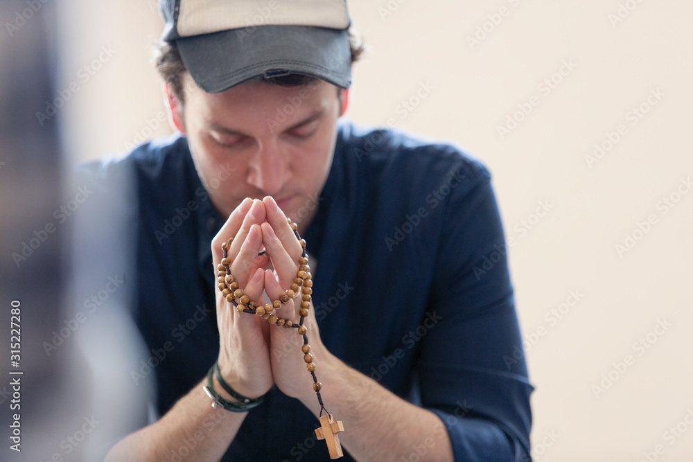 Man praying with rosary Stock Photo | Adobe Stock