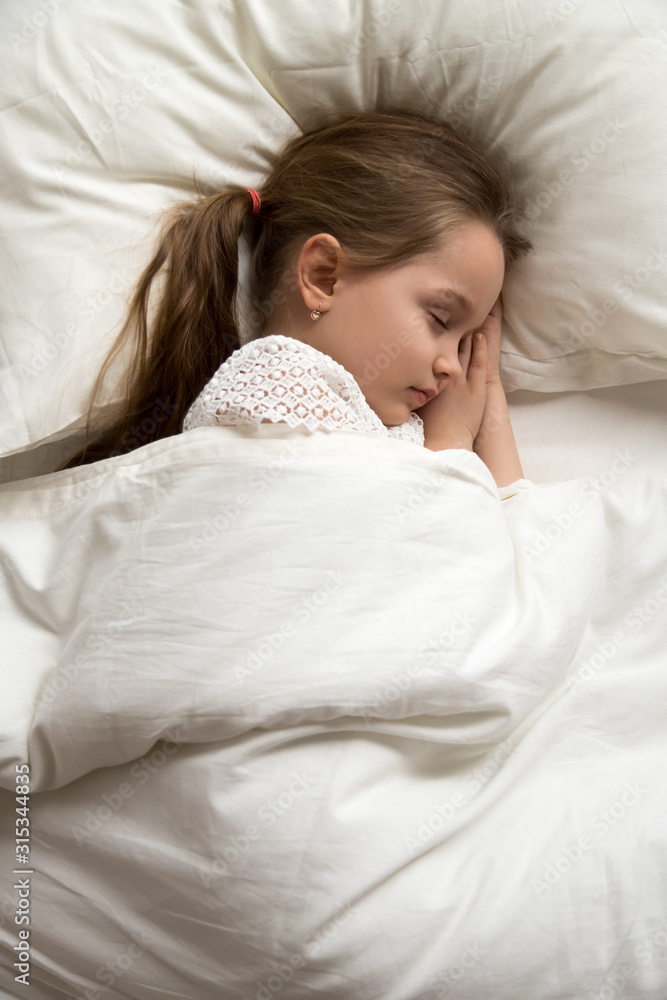 Calm child, little girl sleeping in comfortable bed vertical photo ...