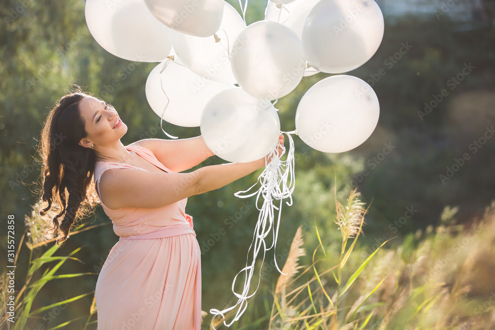 Plus size model posing with white balloons. Stock Photo | Adobe Stock