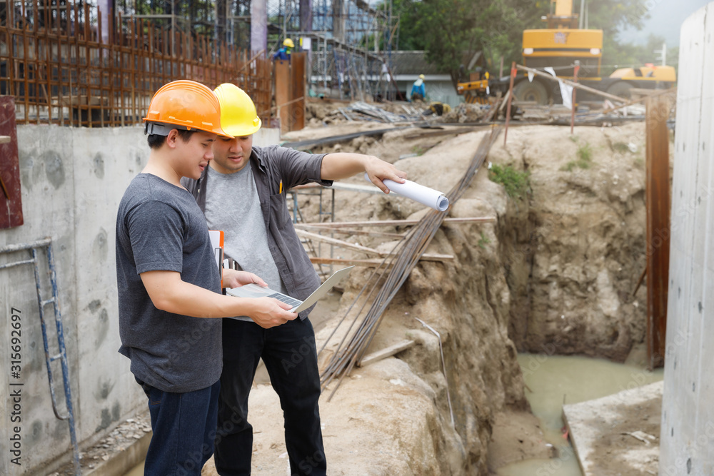 Team of construction workers discussing project details with blueprint ...