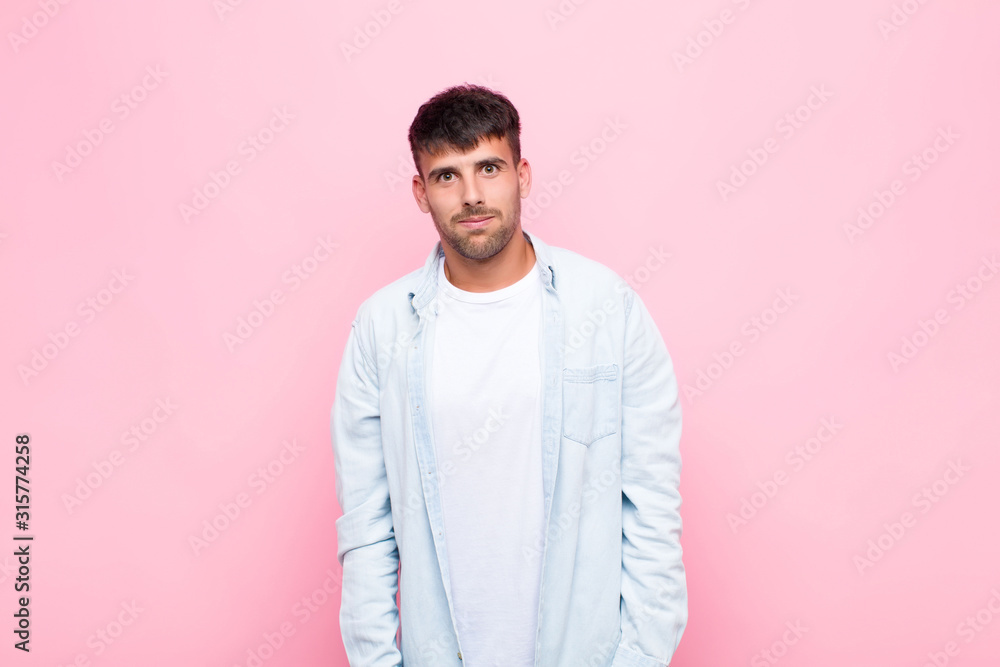 young handsome man with a goofy, crazy, surprised expression, puffing ...