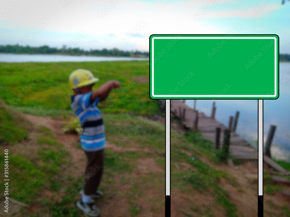 Green traffic sign And the background of the boy standing pose for ...
