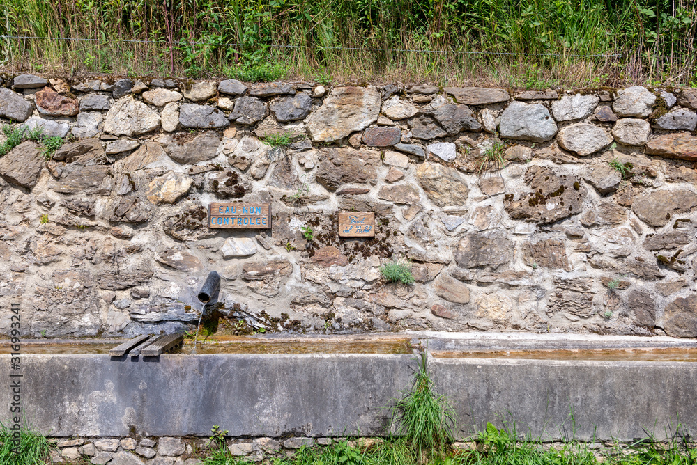 France. Arriège. Une fontaine où coule de l'eau de source et son bassin ...