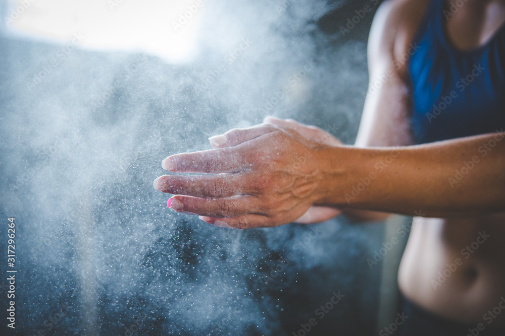 Female fitness model clapping hands with talcum powder in a gym before ...