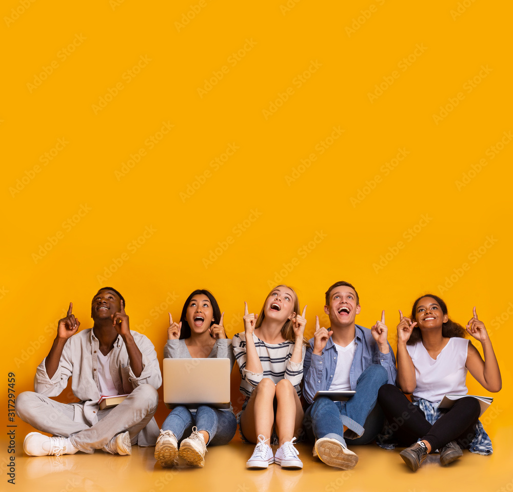 Excited multiracial students pointing up at copy space Stock Photo ...