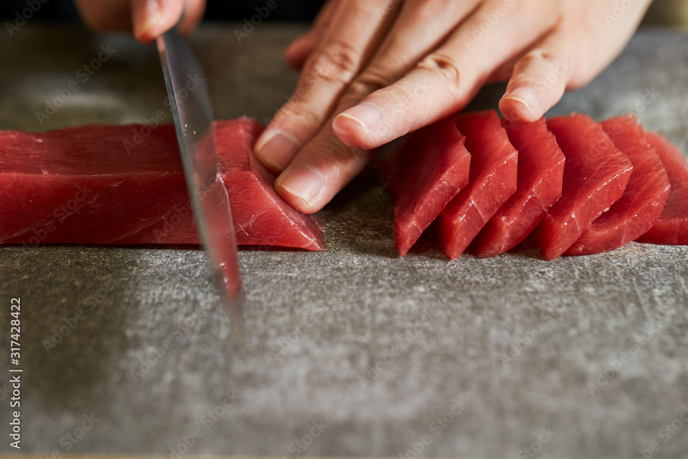 Slicing tuna saku block with sashimi knife Stock Photo | Adobe Stock