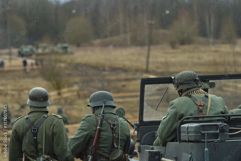 Wehrmacht soldiers during World War II are sitting in helmets with guns ...