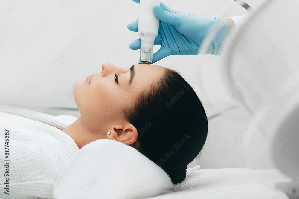 Beautician using machine no-needles mesotherapy smoothes wrinkles of ...