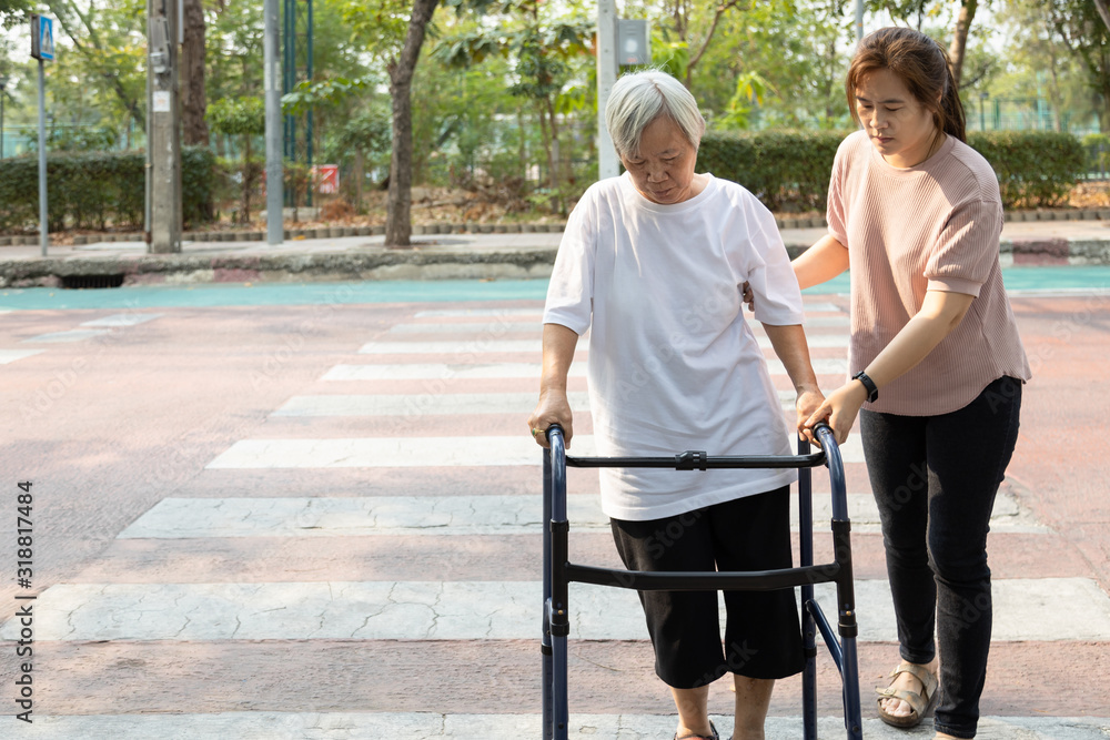 Asian adult daughter assistance and support her senior mother to cross ...