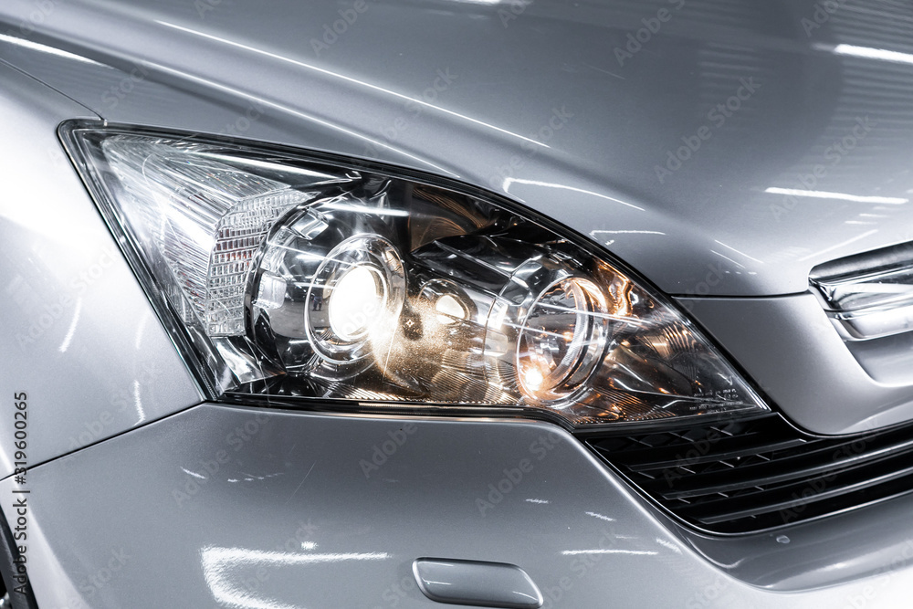 Silver car headlights. Exterior detail. Close up detail on one of the ...