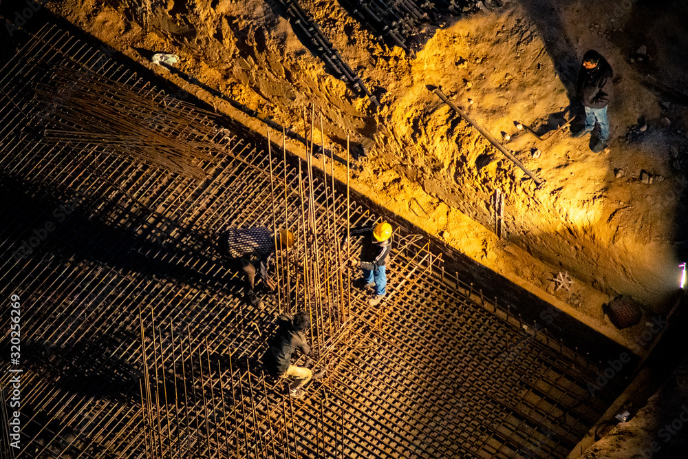 Construction workers in India standing on a rebar reinforcing bar ...