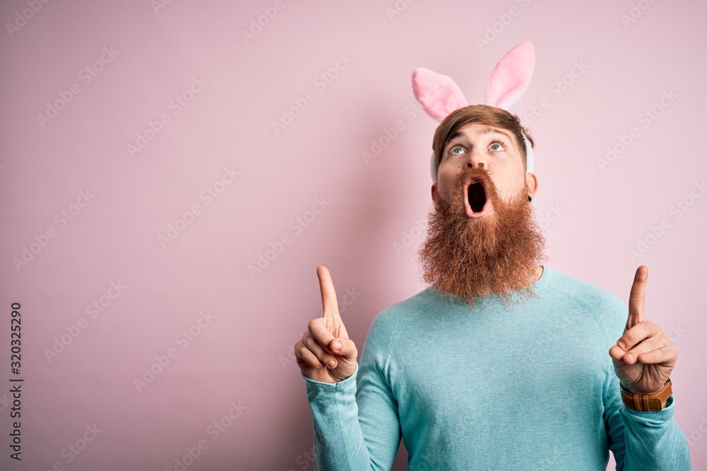 Hipster Irish man with beard wearing easter rabbit ears over isolated ...