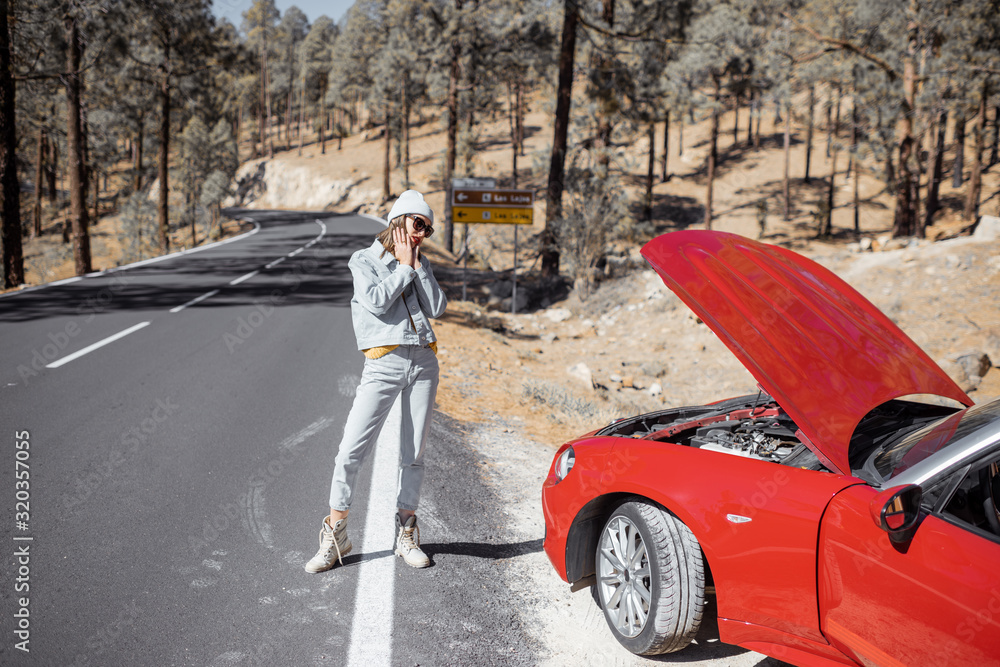 Frustrated woman standing on the roadside, having some problems with a ...