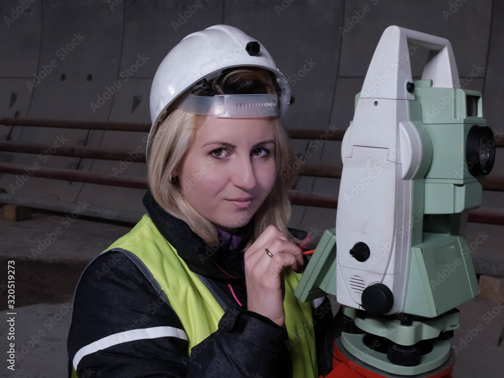 Portrait of pretty young mining surveyor woman in hardhat standing by ...