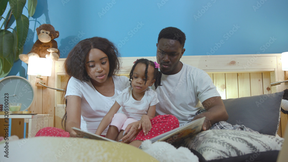 Black African loving parents upbringing a child reading exciting ...