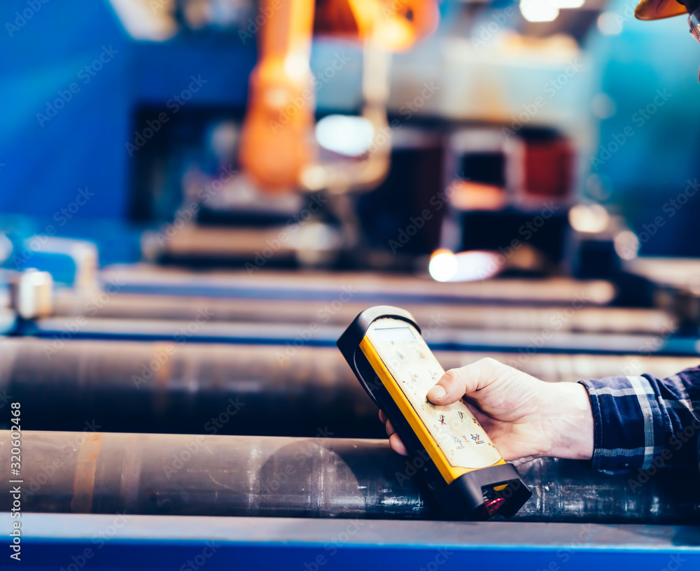 Worker operating robotic arm to cut steel in a factory. Stock Photo ...