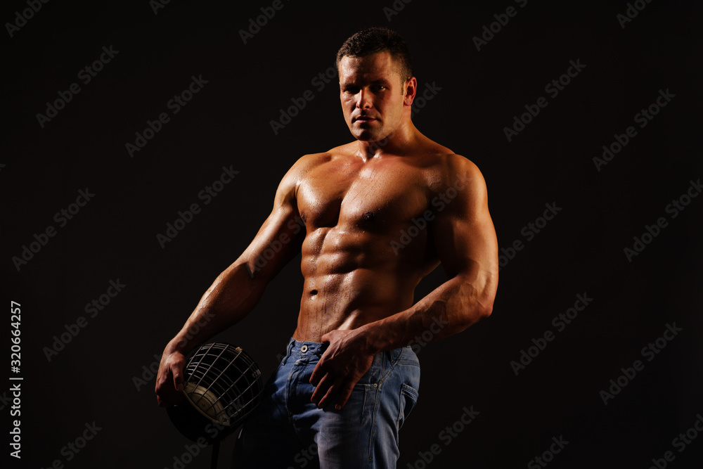 Muscular sporty man with helmet. Sexy sportsmen in black background. Ab ...