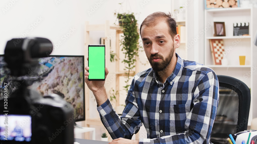 Attractive influencer recording review of phone with green screen Stock ...