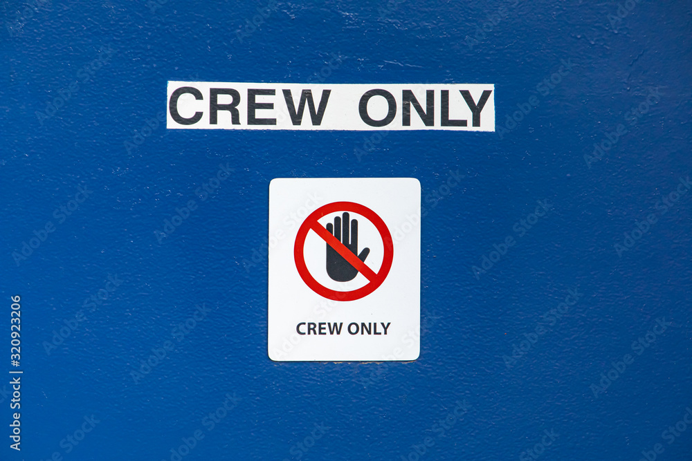 Black lettered signboard on blue background saying Crew Only. Warning ...