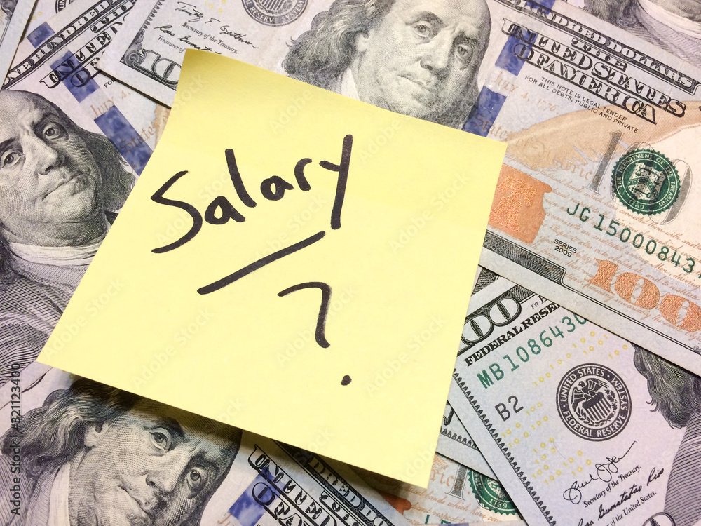 American cash money and yellow paper note with text Salary with ...