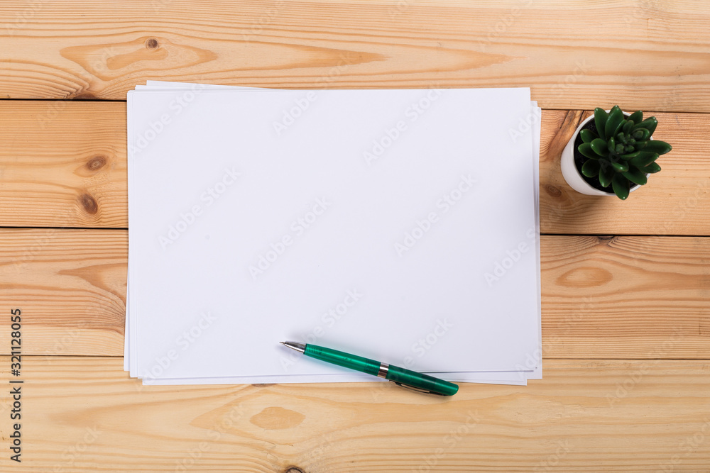 A4 white paper with pen on wooden background. Blank branding template ...