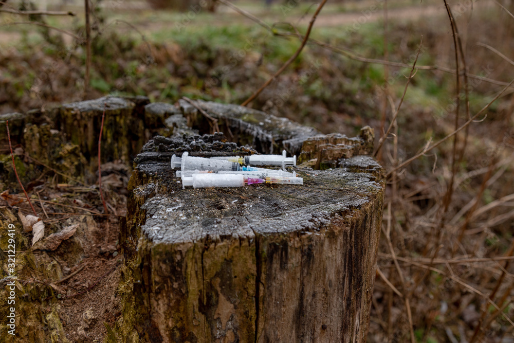 Several Used NeverShare Heroin Syringe with Vomit laying on the frozen ...