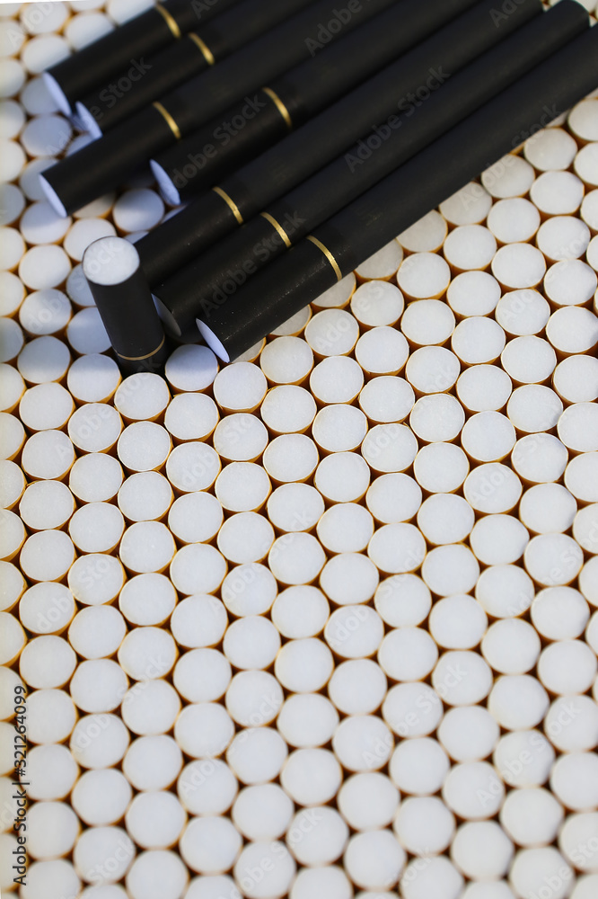 Cigarette filters Blank cigarette paper top view Several white and ...