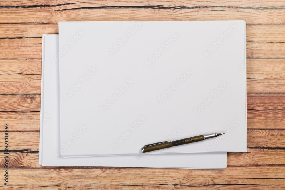 A4 white paper with pen on wooden background. Blank branding template ...
