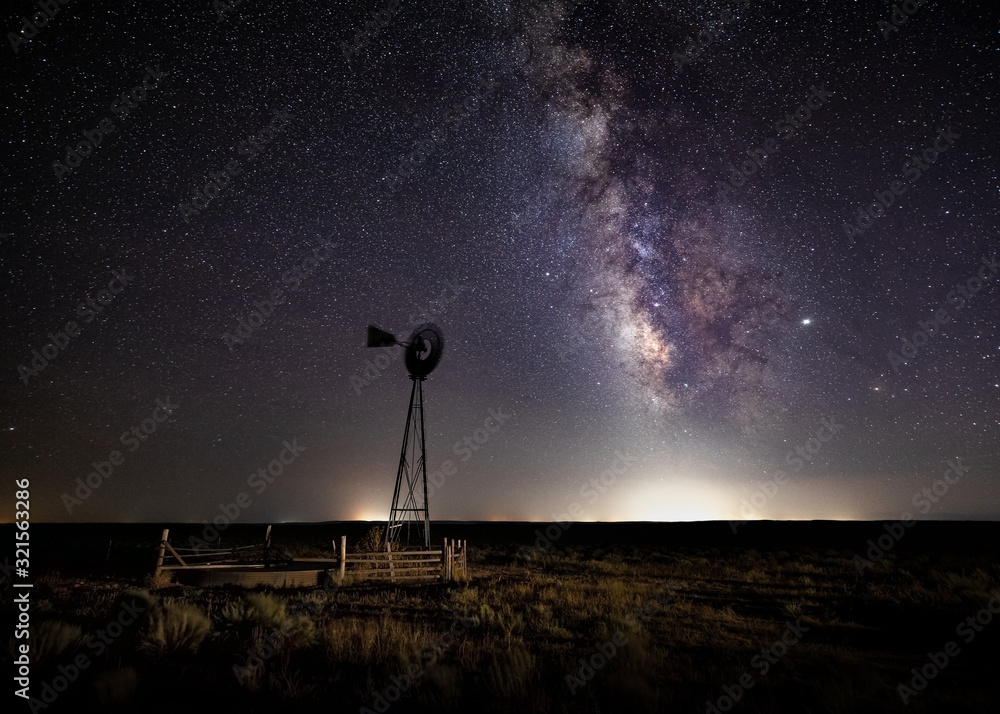 Old fashion windmill on a farm with the Milky Way visible in the night ...