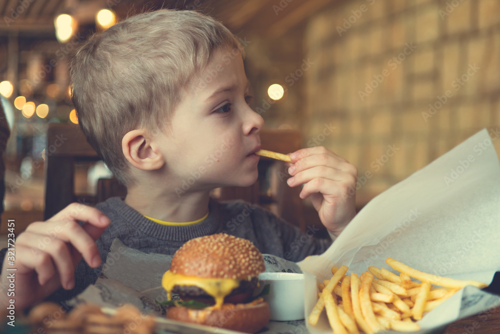 child eats a mini Burger and fries. children's menu in the cafe Stock ...